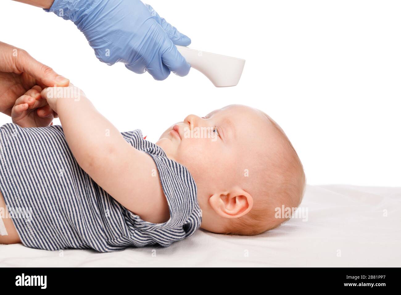 Pediatrician or nurse checks baby boy's body temperature using infrared ...