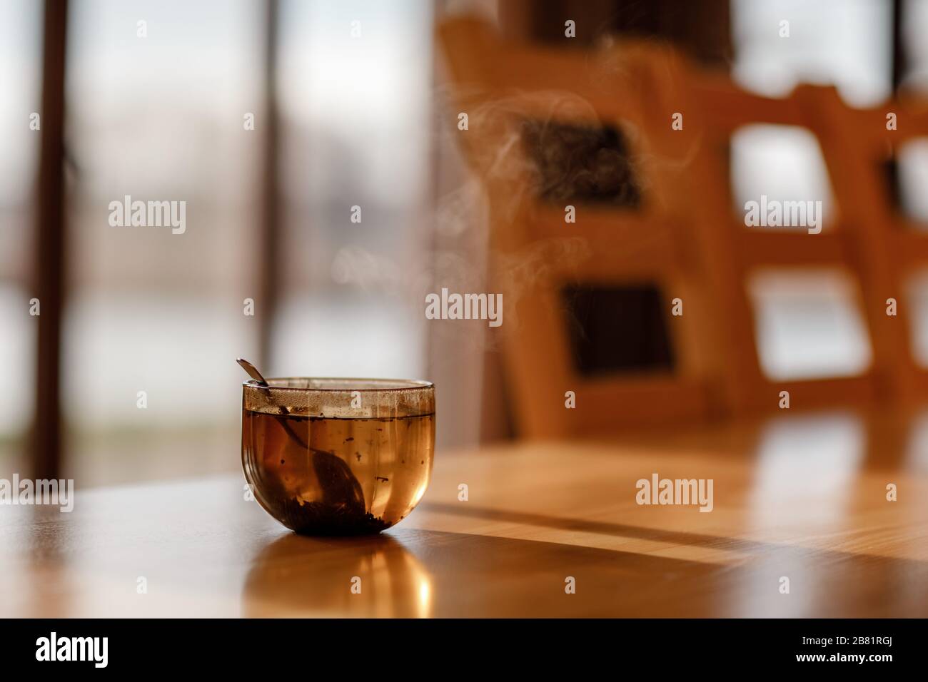 Cup of tea with steam on wooden table in the living room. selective ...