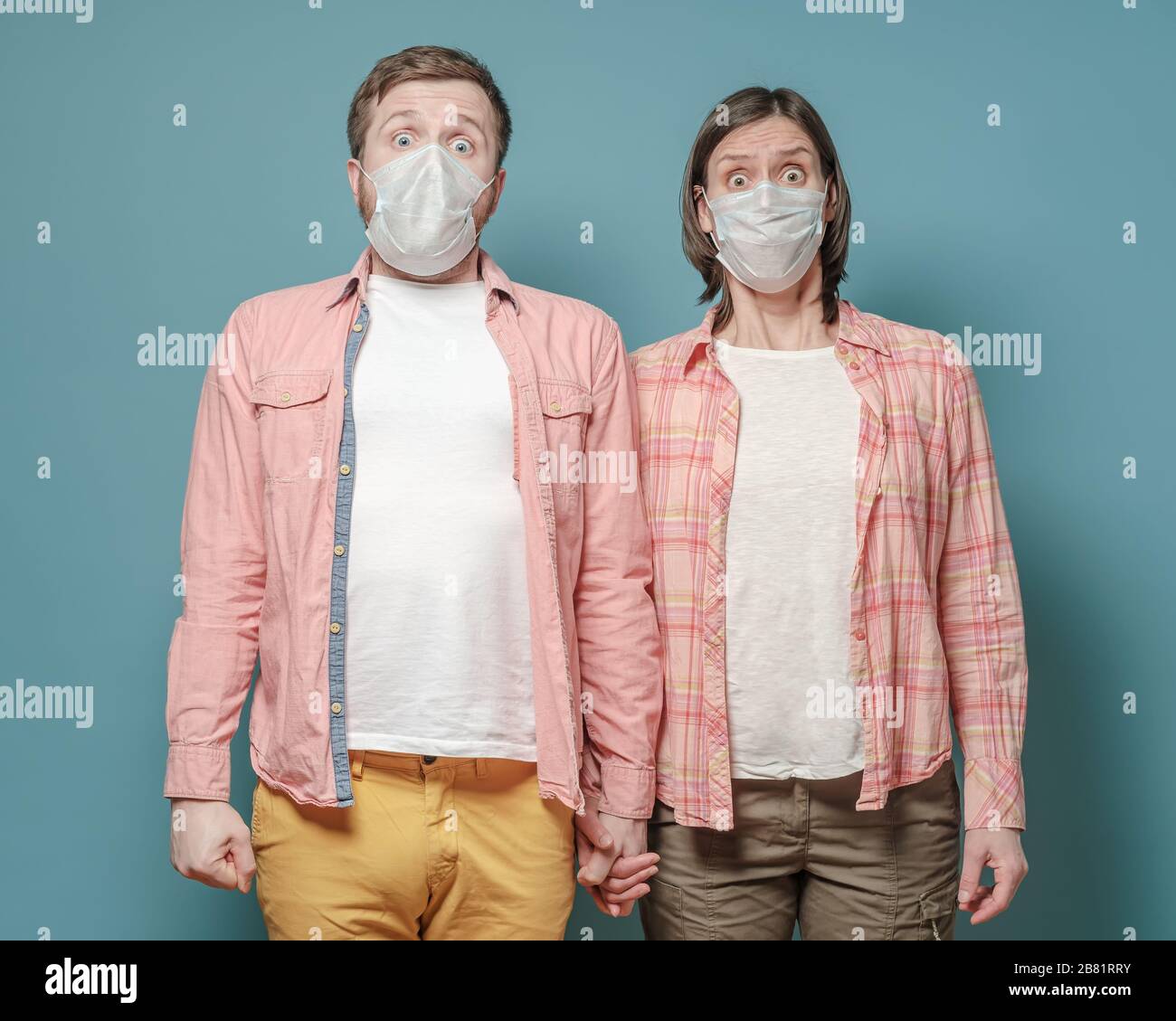 Strange man and woman in medical masks hold hands, they are in a panic ...