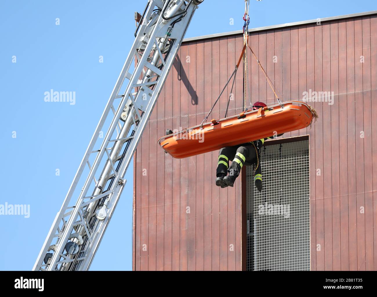suspended firefighter with stretcher with people and the big crane ...