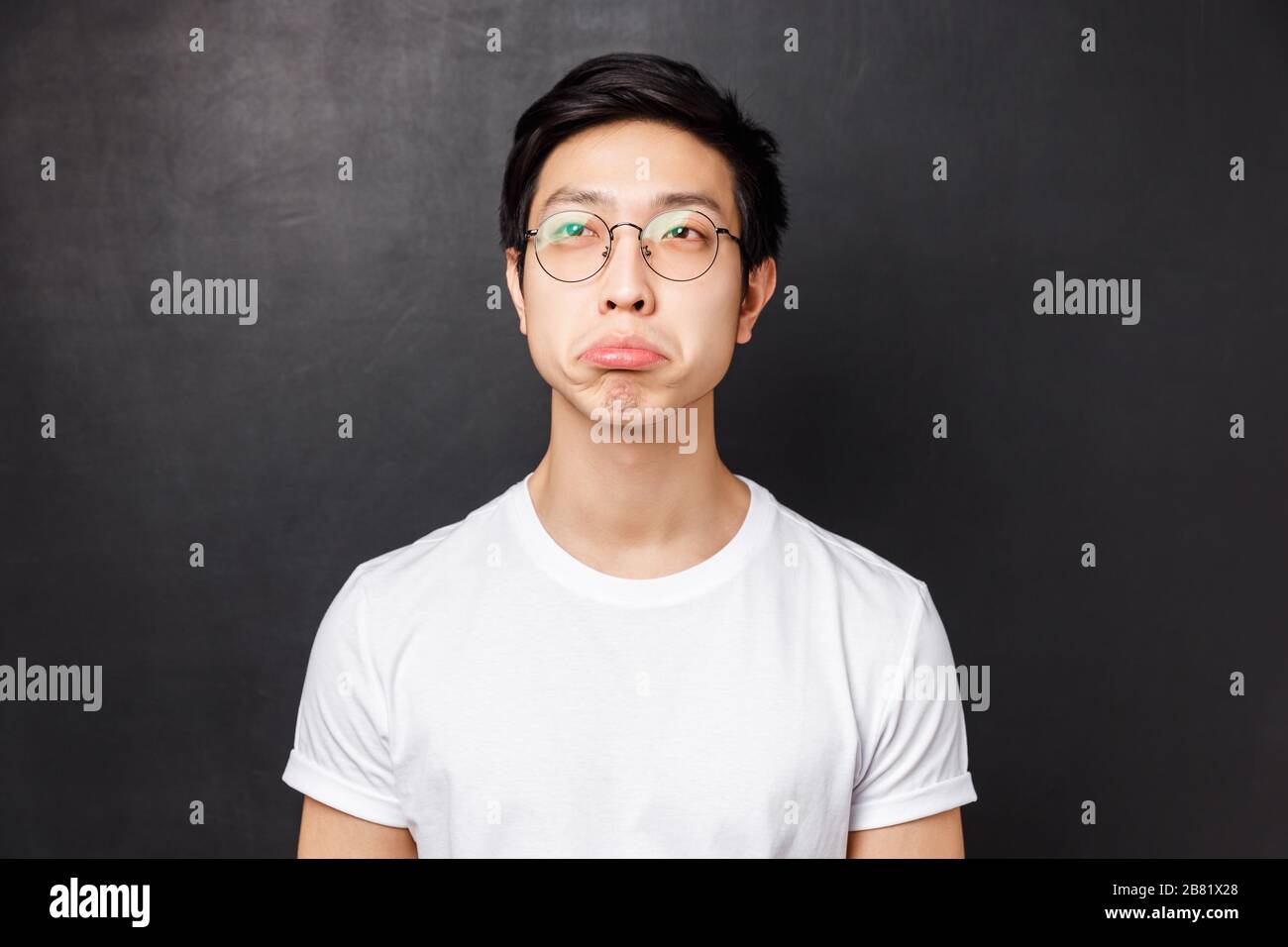 Close-up portrait of impressed asian young man in white t-shirt and ...