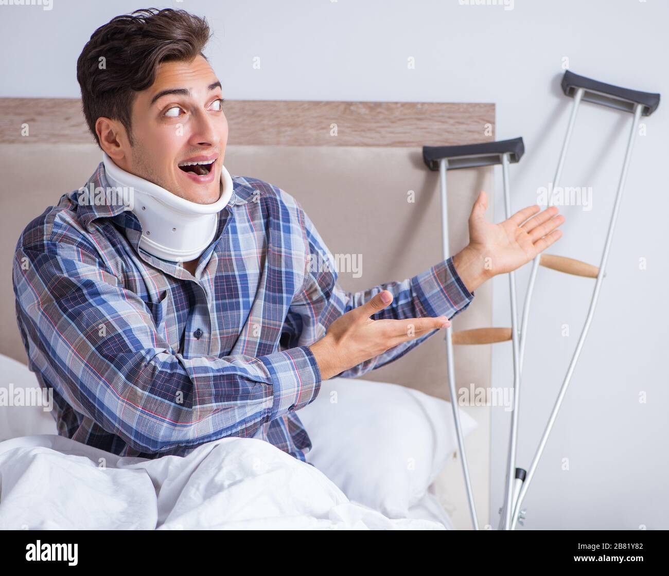 Injured man in bed at home with crutches hi-res stock photography and ...
