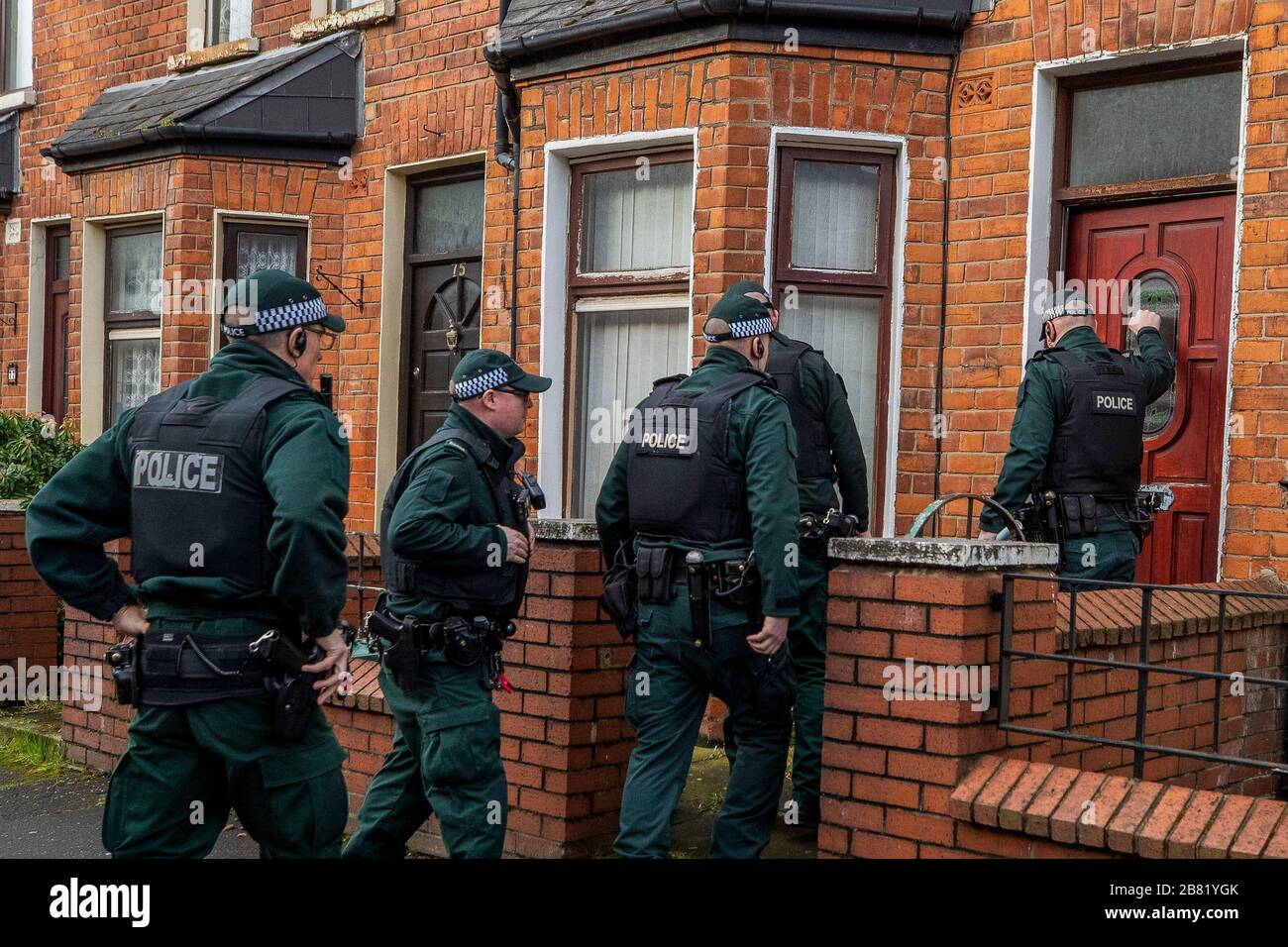 PSNI TSG officers enter a property during a search in a terraced street ...