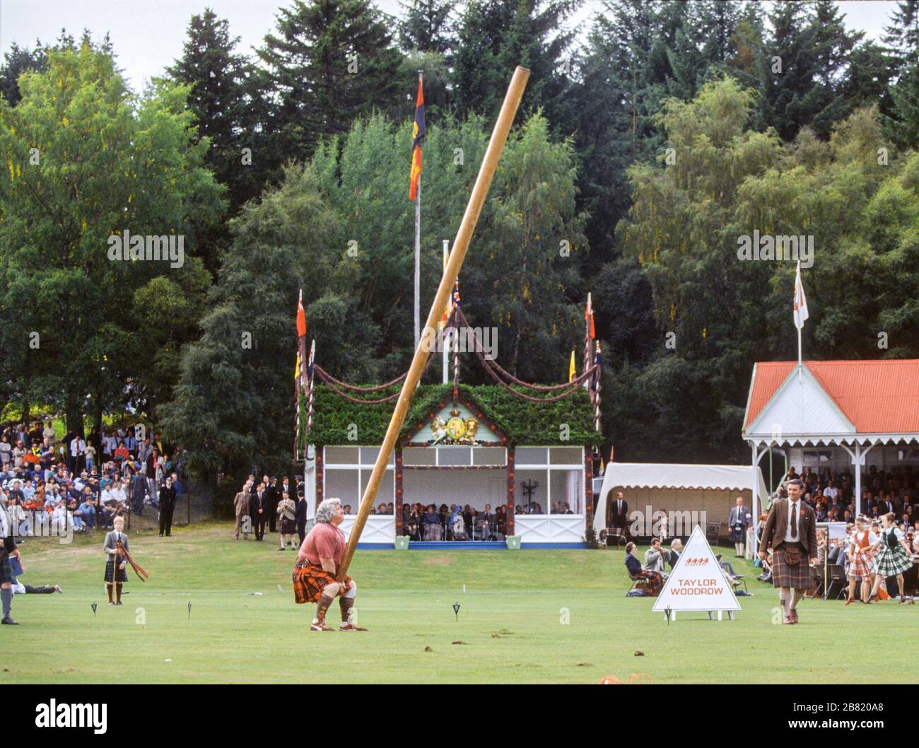 A highlander tosses the caber watched by HM Queen Elizabeth II and ...
