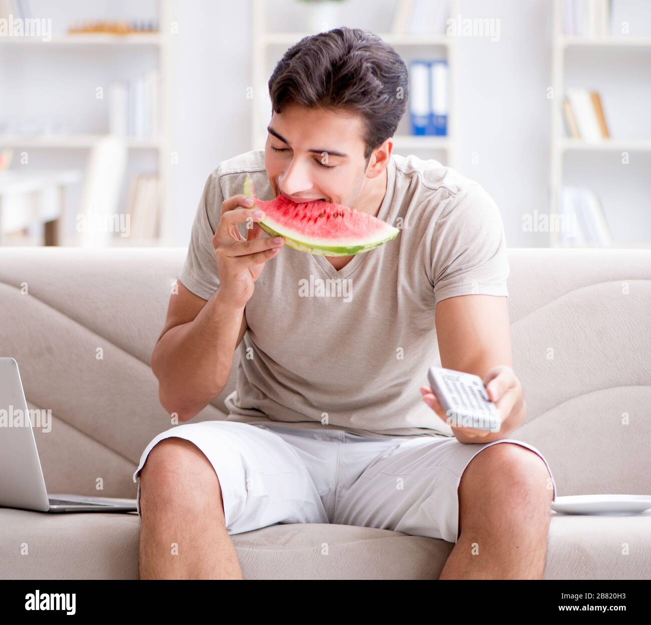The man eating watermelon at home Stock Photo - Alamy