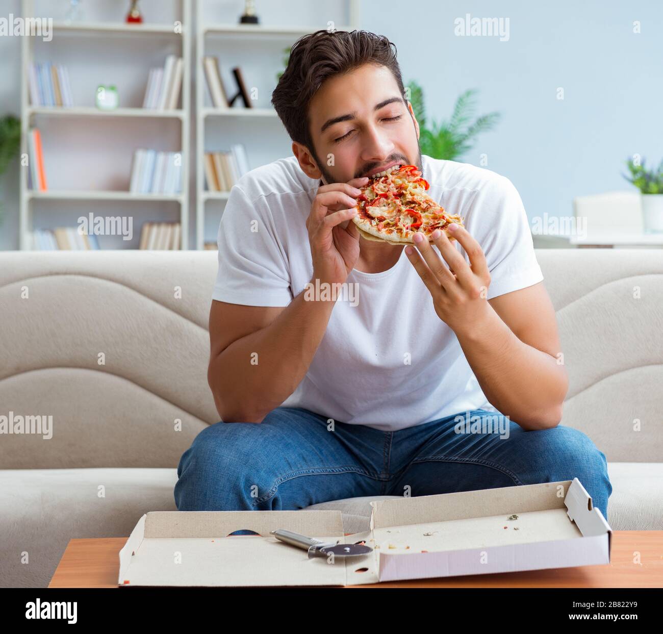 The man eating pizza having a takeaway at home relaxing resting Stock ...