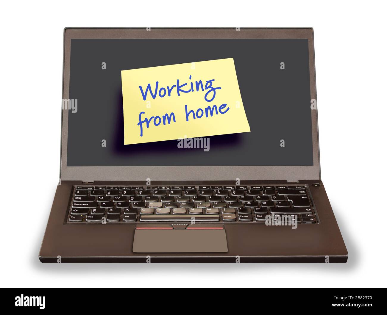 Notebook pc with a yellow sticky note saying Working from home on the ...