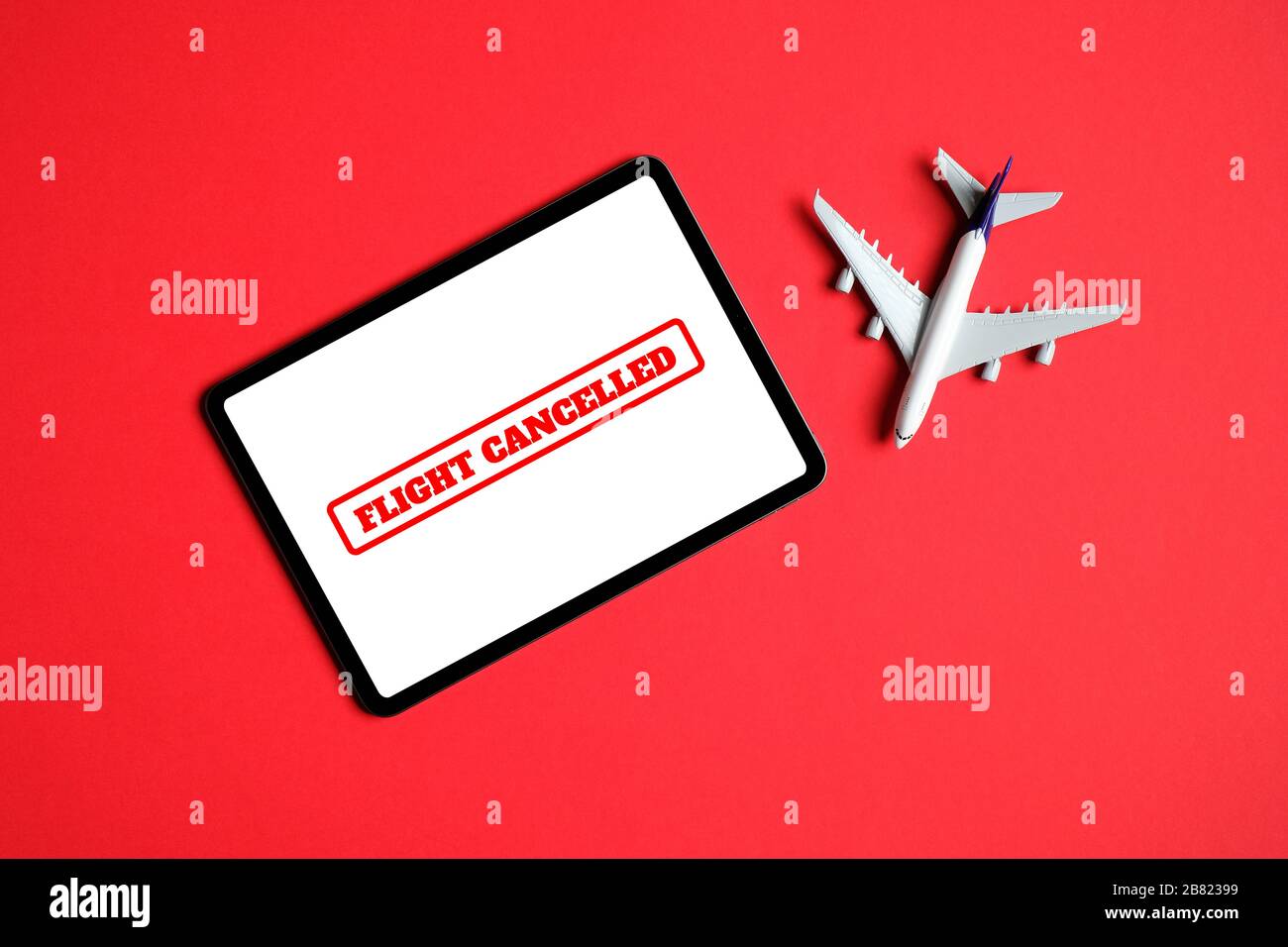 Flight cancelled concept. Plane model and tablet with stamp "Flight ...