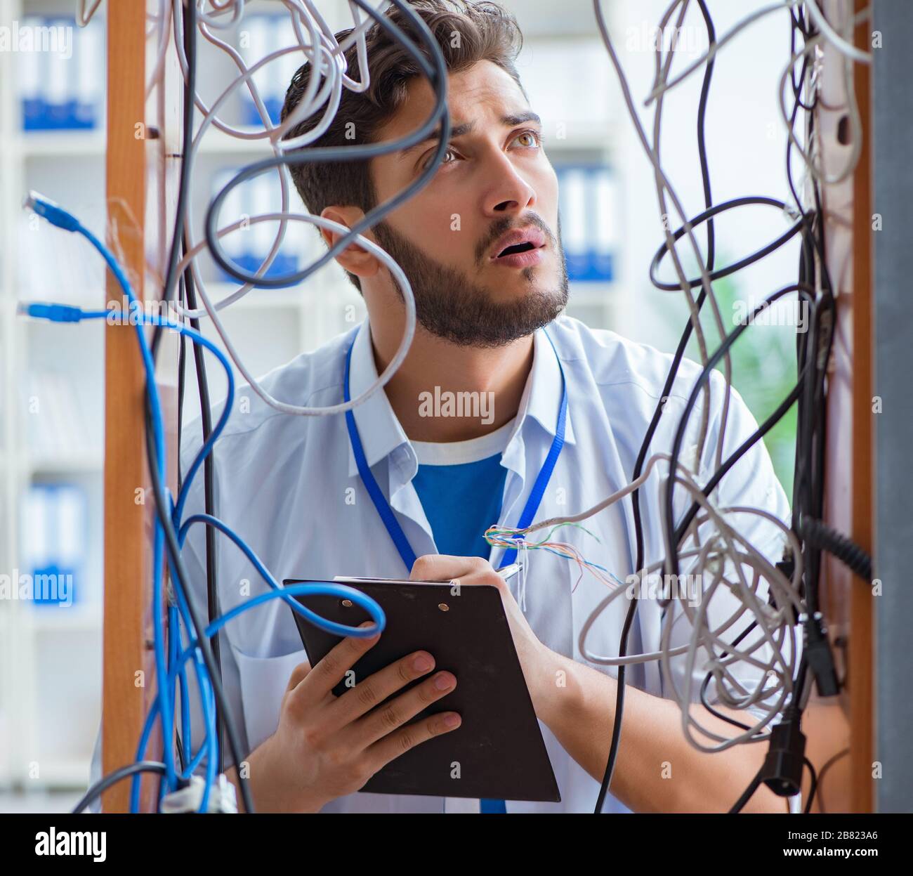 The electrician trying to untangle wires in repair concept Stock Photo ...