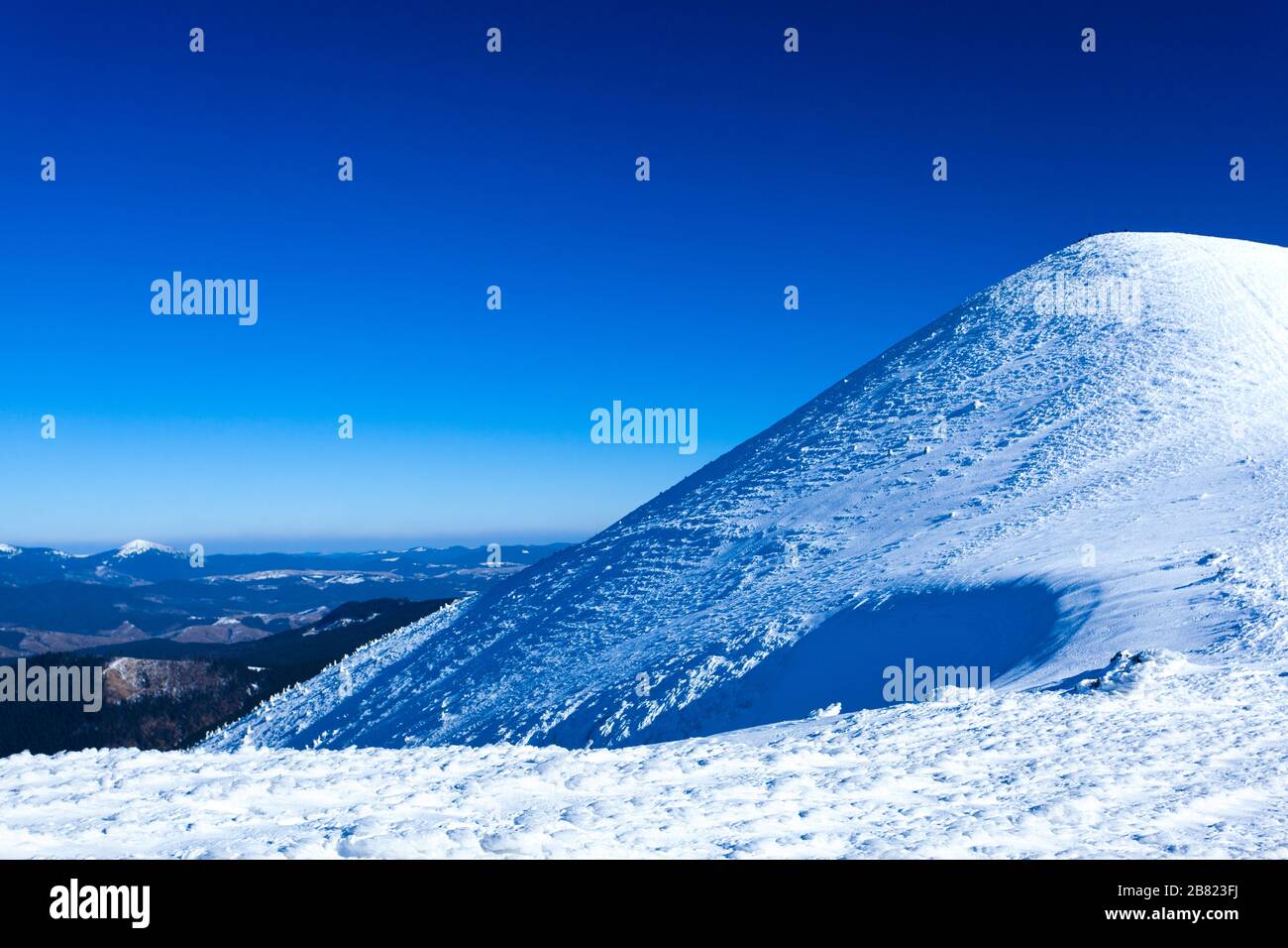 Landscape of snow winter valley surrounded by hills and sun in above on ...