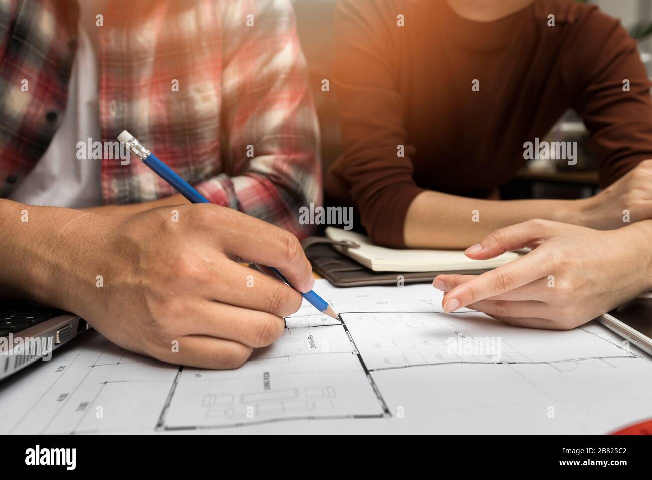 Group of two coworkers working with blueprint in office. co-working ...