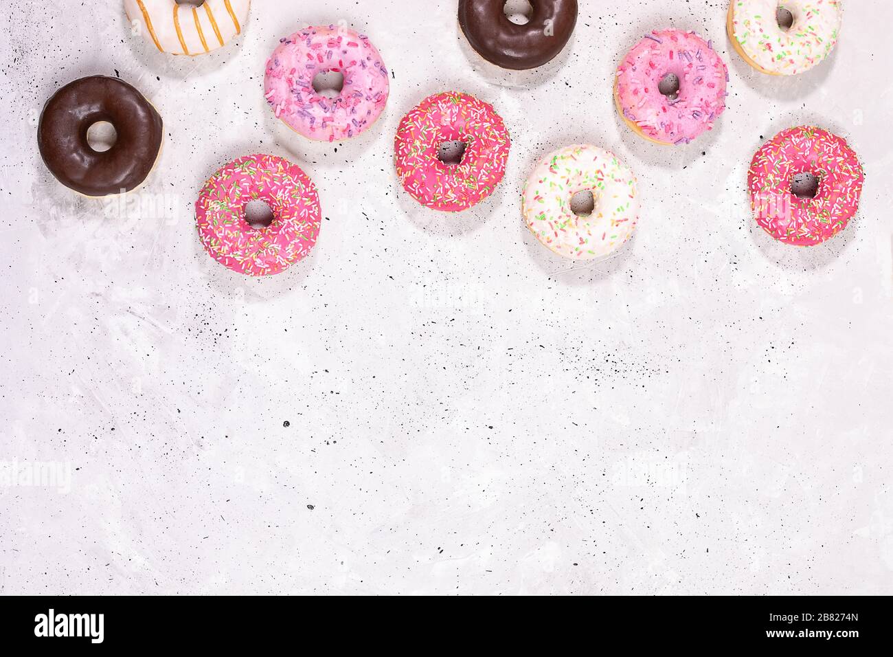Doughnuts with multicolored glaze laid out on concrete background ...