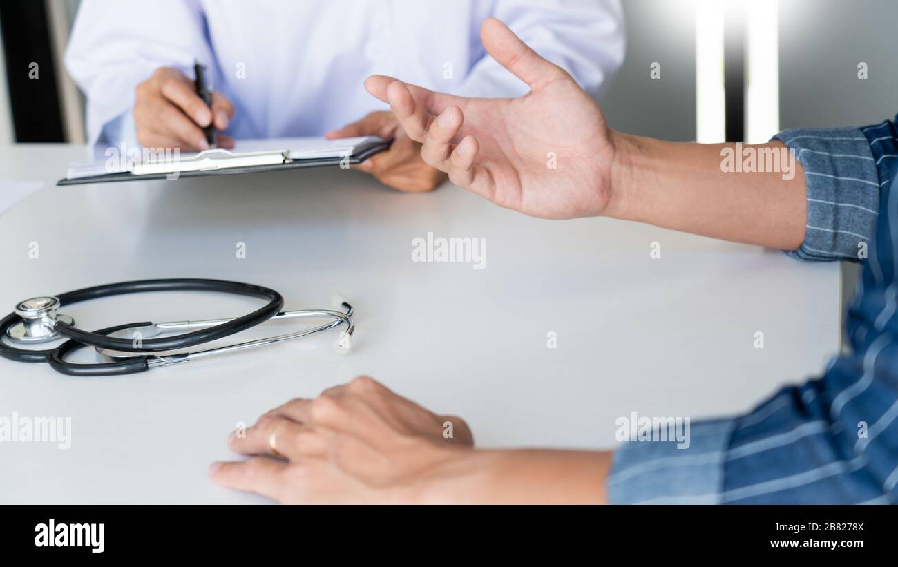 doctor working with patient taking notes with clipboard and discussing ...