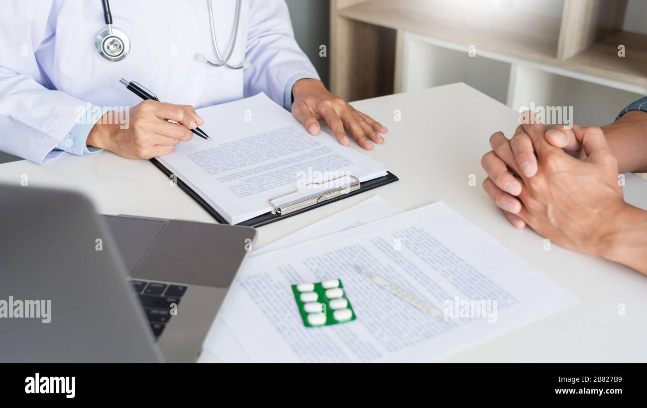doctor working with patient taking notes with clipboard and discussing ...