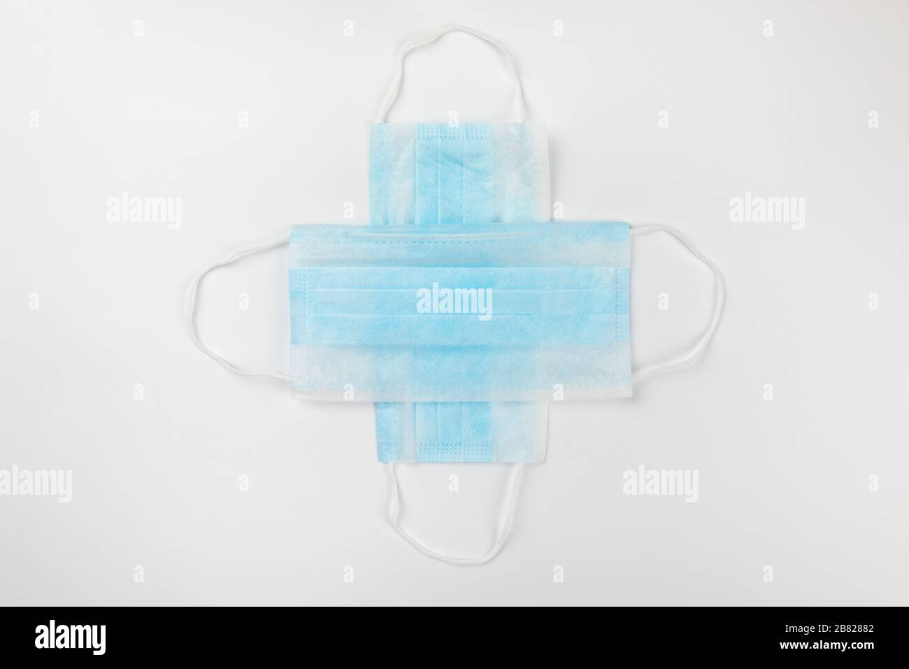 two blue surgical medical masks on white background Stock Photo - Alamy