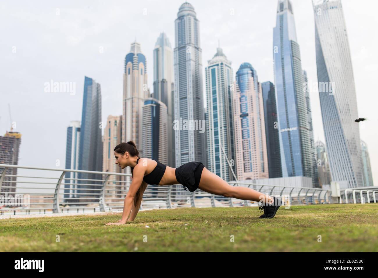Young fit woman make plank exercises in front of skyscrapers Stock ...