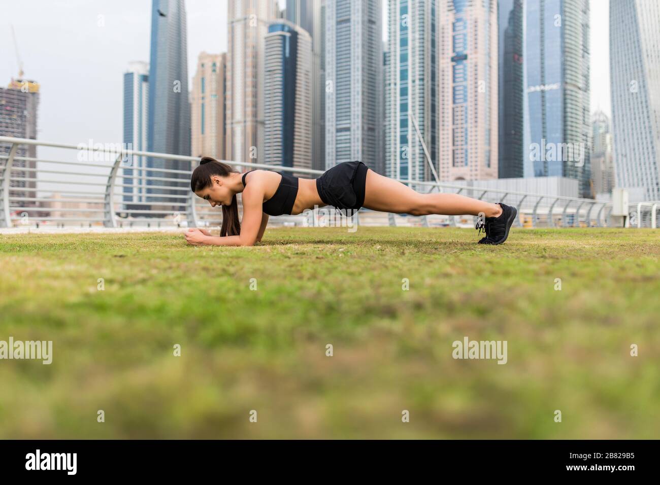 Young fit woman make plank exercises in front of skyscrapers Stock ...