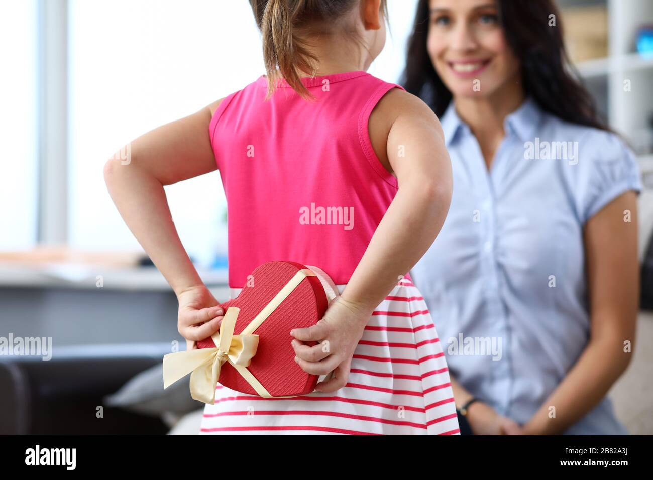 Girl giving present to mommy Stock Photo - Alamy