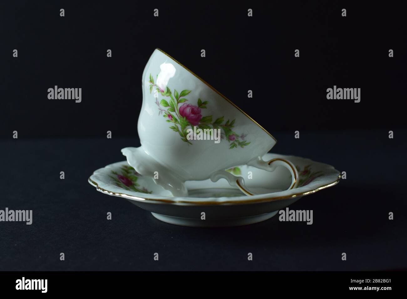 Tilted Rose Teacup on Black Background Stock Photo - Alamy