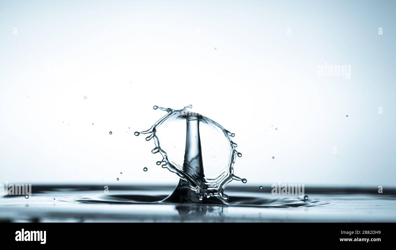 Close-up of a water drop falling on water surface Stock Photo - Alamy