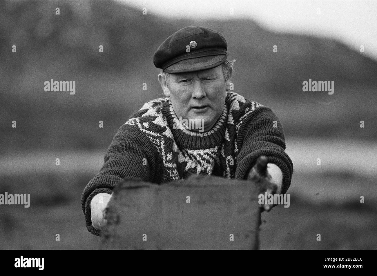A man cutting peat on a stretch of land on the island of Lewis in the ...