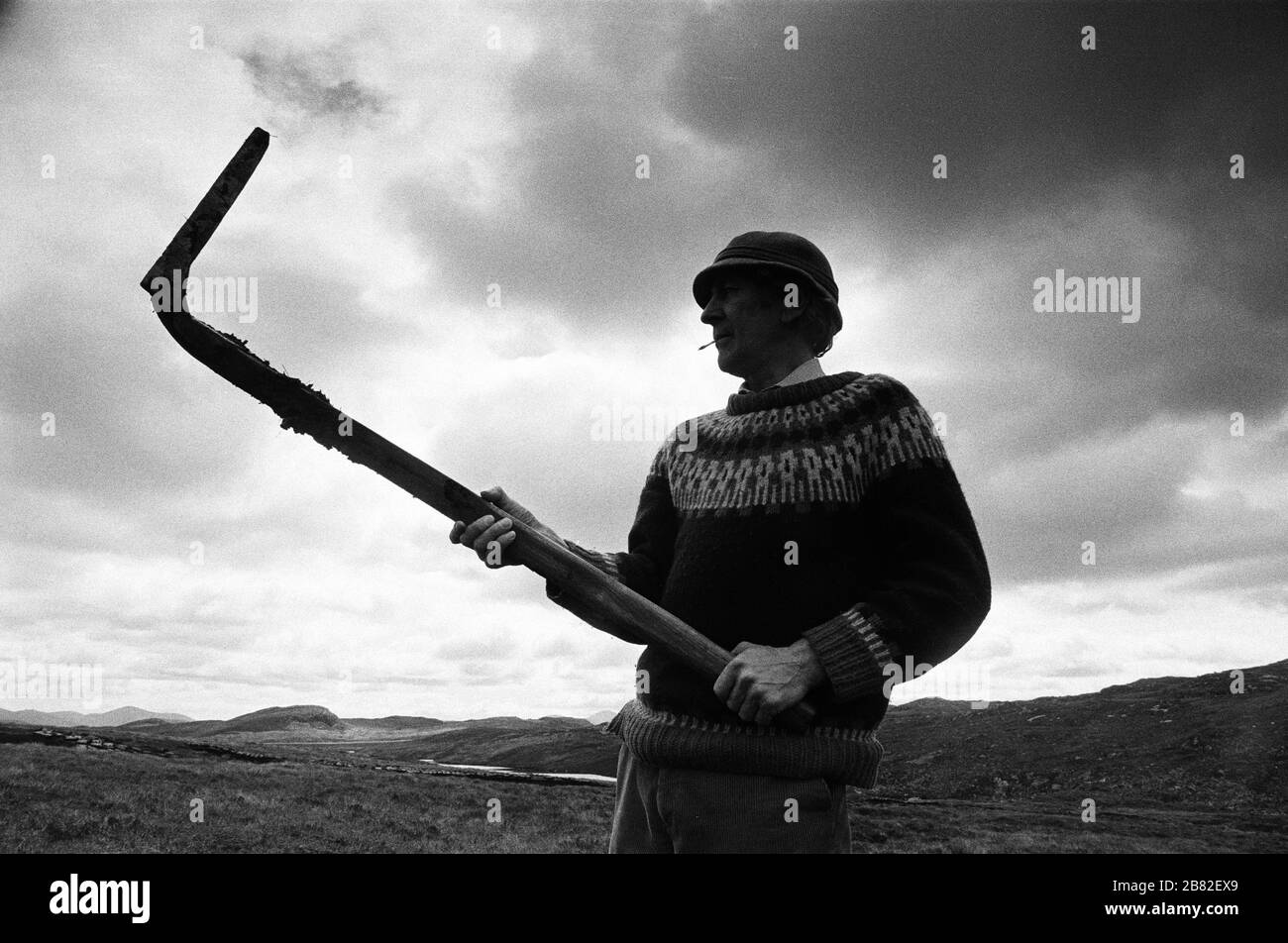 A man cutting peat on a stretch of land on the island of Lewis in the ...