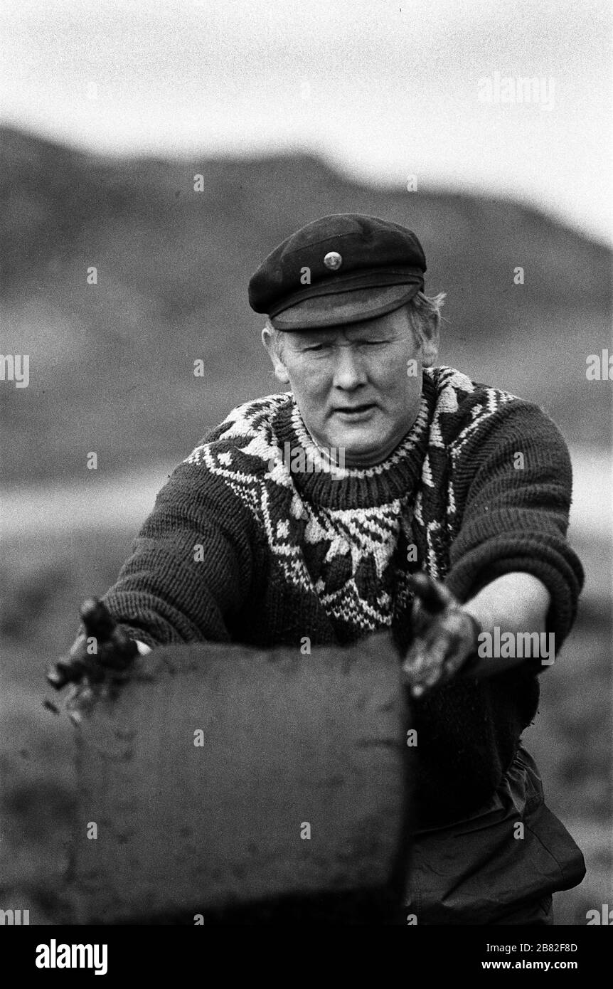 A man cutting peat on a stretch of land on the island of Lewis in the ...