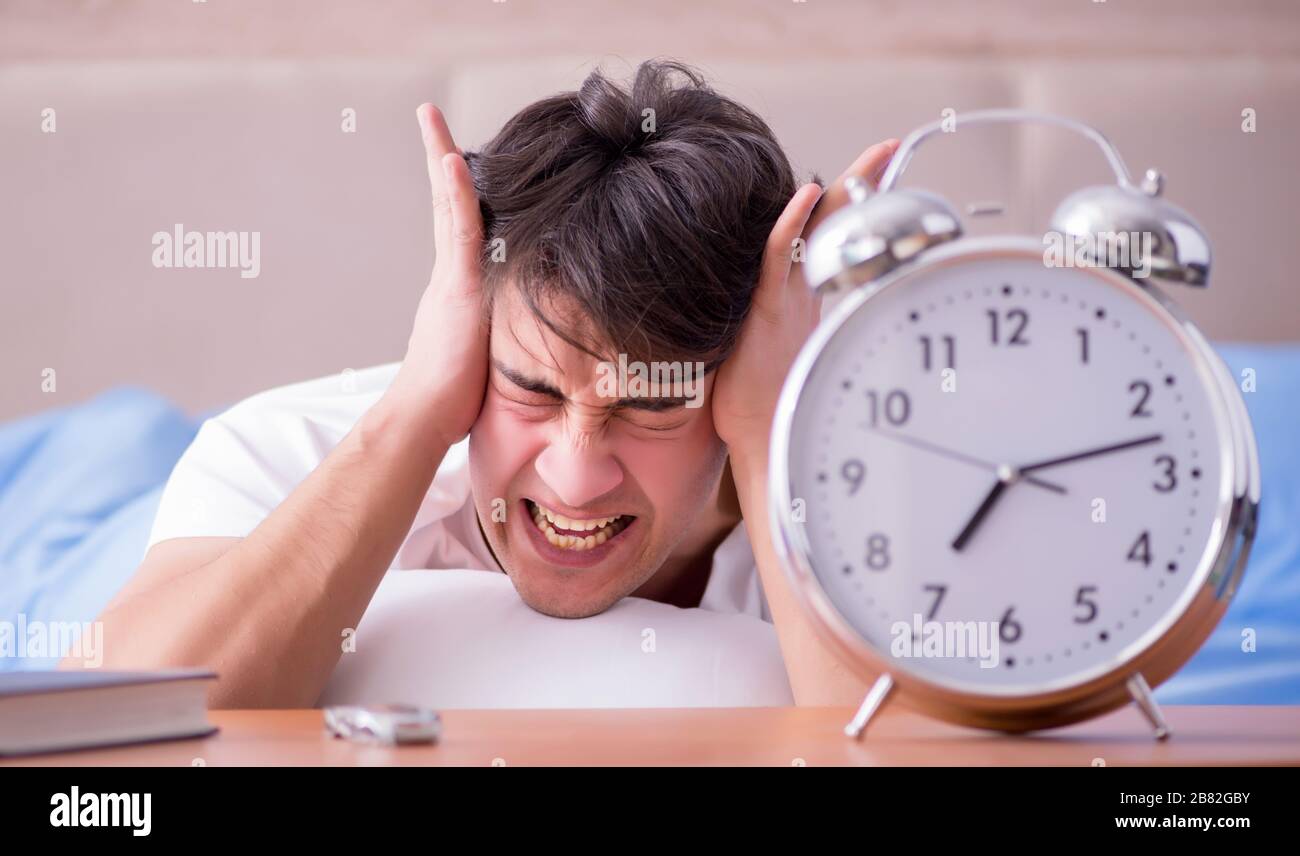 Man in bed frustrated suffering from insomnia with an alarm clock Stock ...