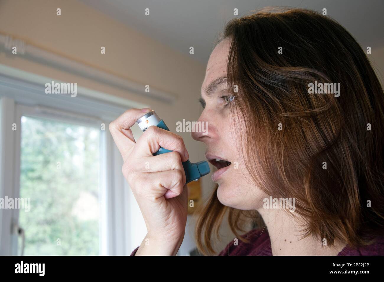 Woman using asthma inhaler Stock Photo - Alamy