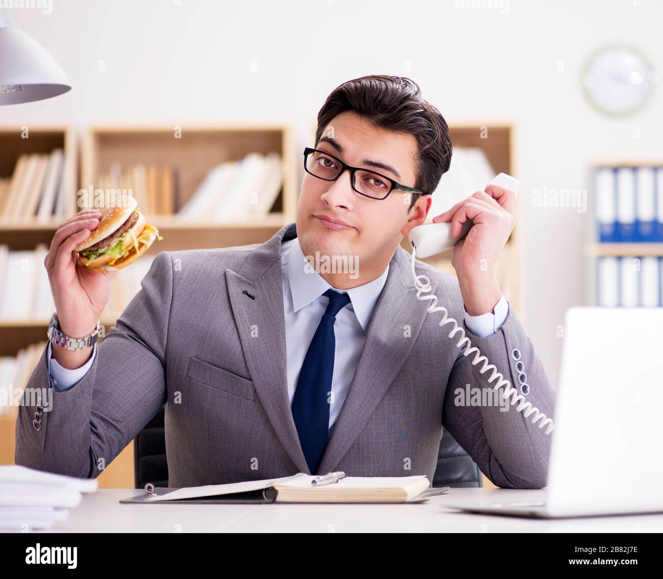 The hungry funny businessman eating junk food sandwich Stock Photo - Alamy