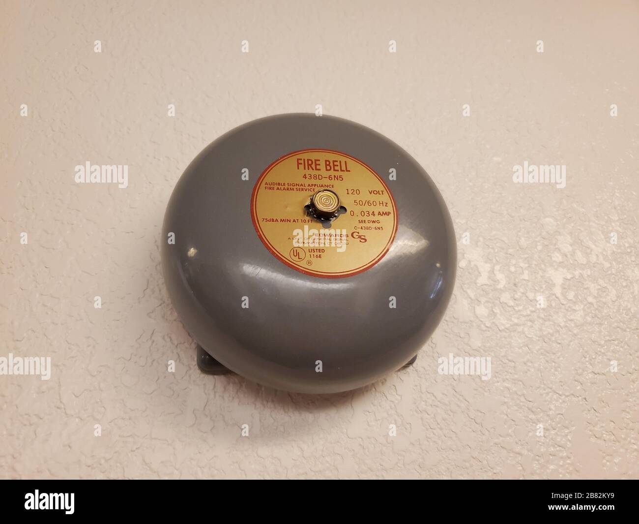Close-up of mechanical fire alarm fire bell on white wall at facility ...