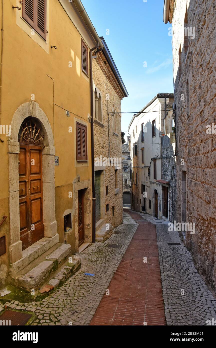 A narrow street between the old houses of Veroli, a medieval village in ...