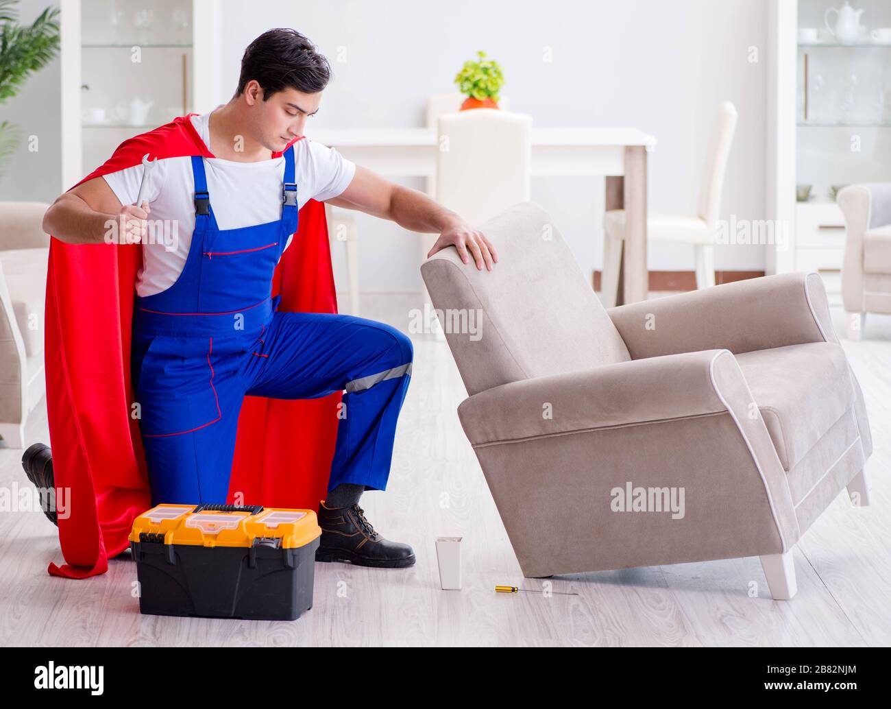 The superhero repairman with tools in repair concept Stock Photo - Alamy