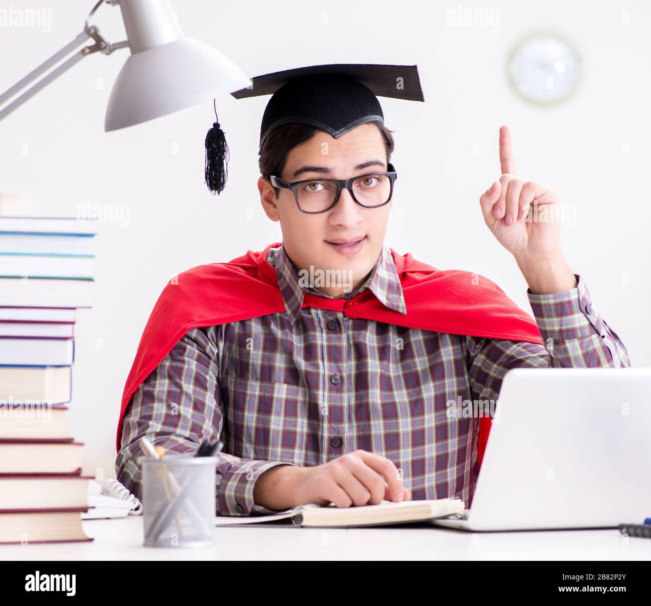The super hero student wearing a mortarboard studying for exams Stock ...