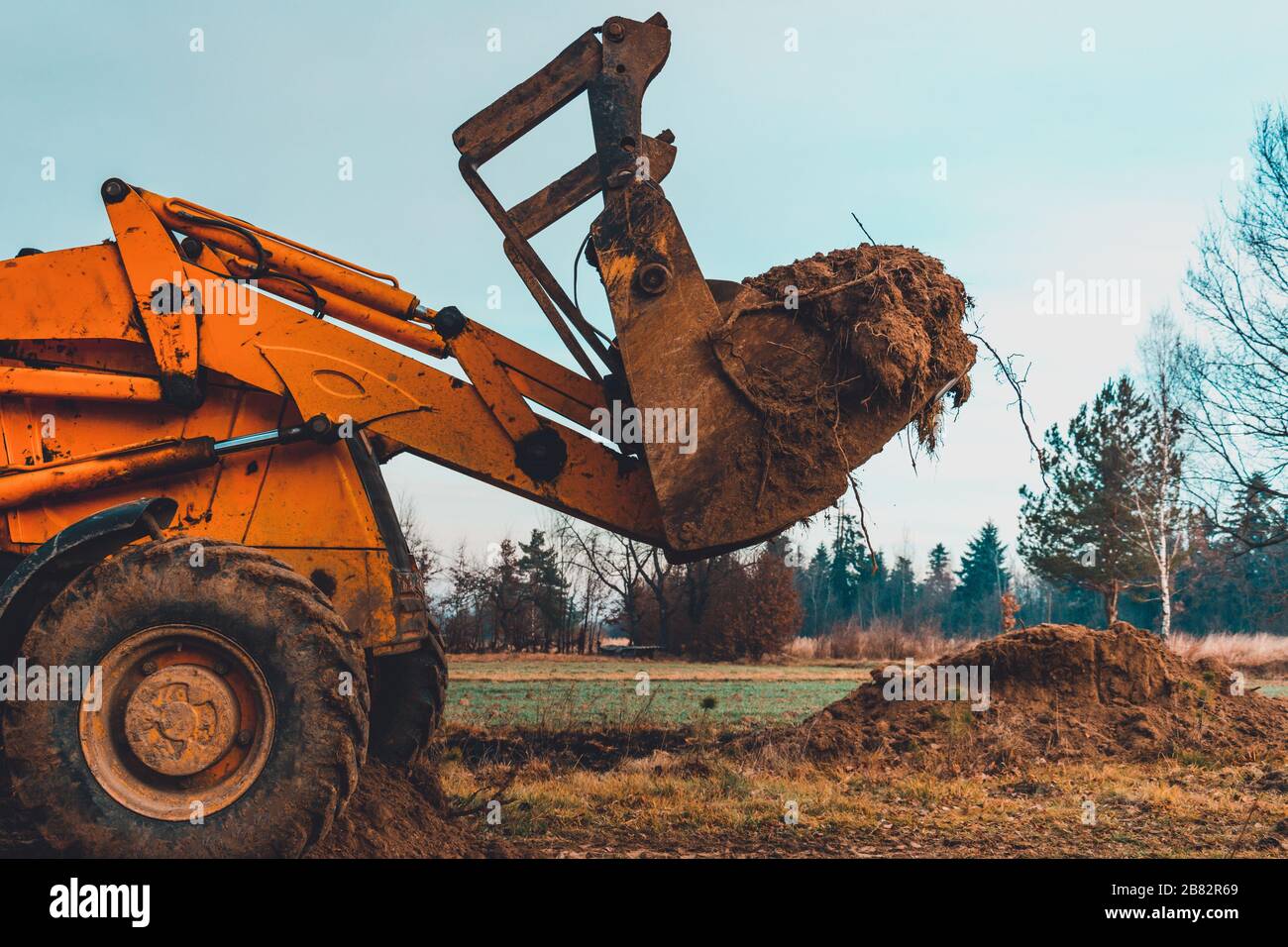 Closeup of a large bucket excavator digging the ground to set the road ...
