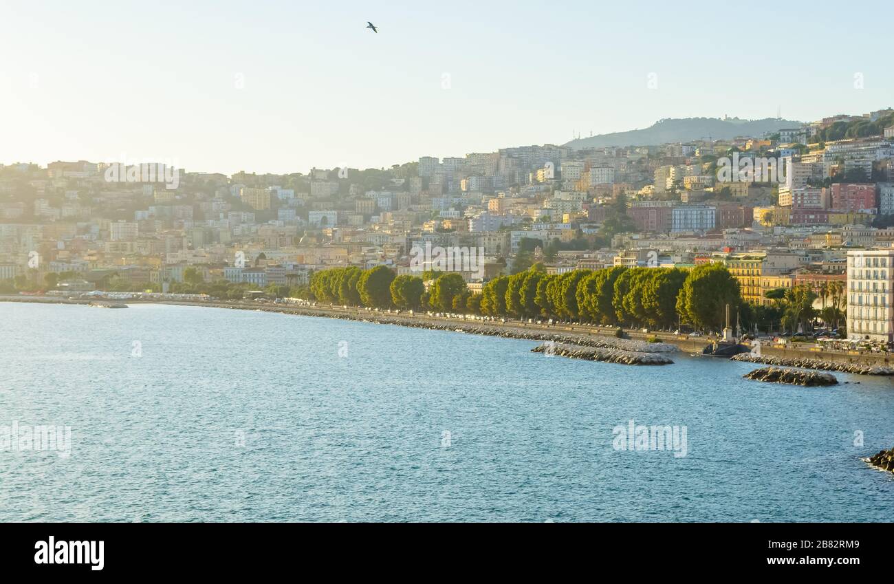 Panoramic view from the waterfront of Naples, Italy. The sunset warm ...