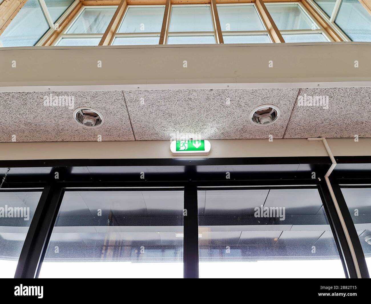 Close up view of green white wall and ceiling light, emergency exit ...
