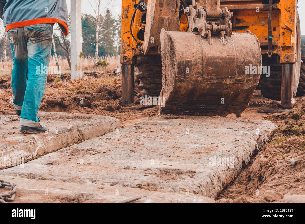 The excavator installs concrete slabs for the road Stock Photo - Alamy