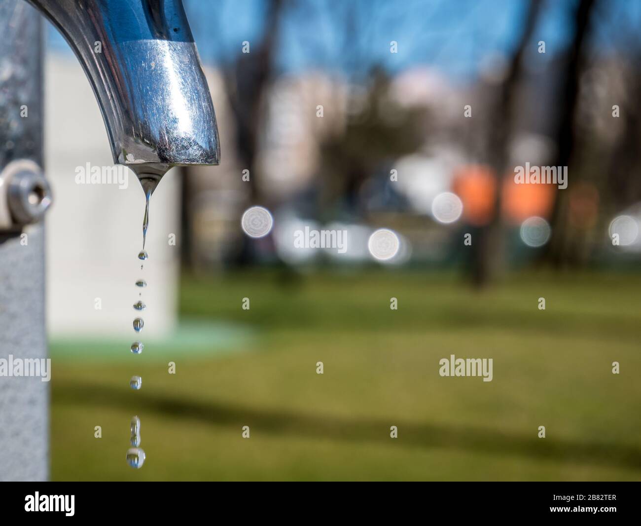 Water dripping from a water tap. Drop of water close up with a blurred ...