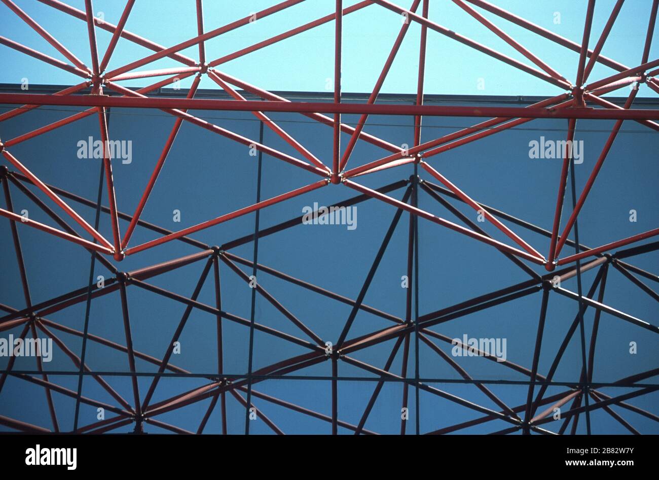 Reflections and structure. A red, painted, steel structure reflected in ...