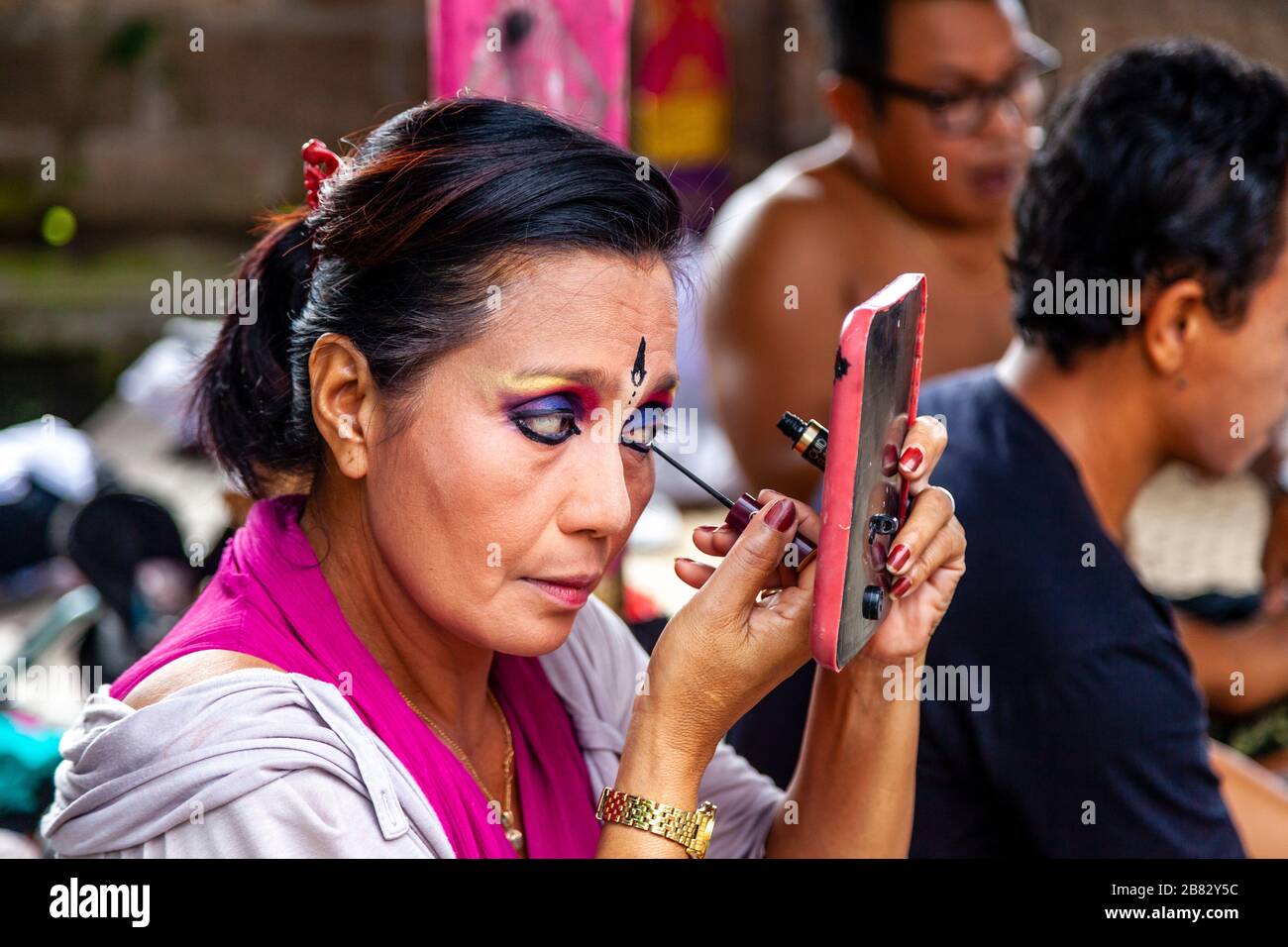 A Woman Applies Make Up Before Performing In A Traditional Balinese ...