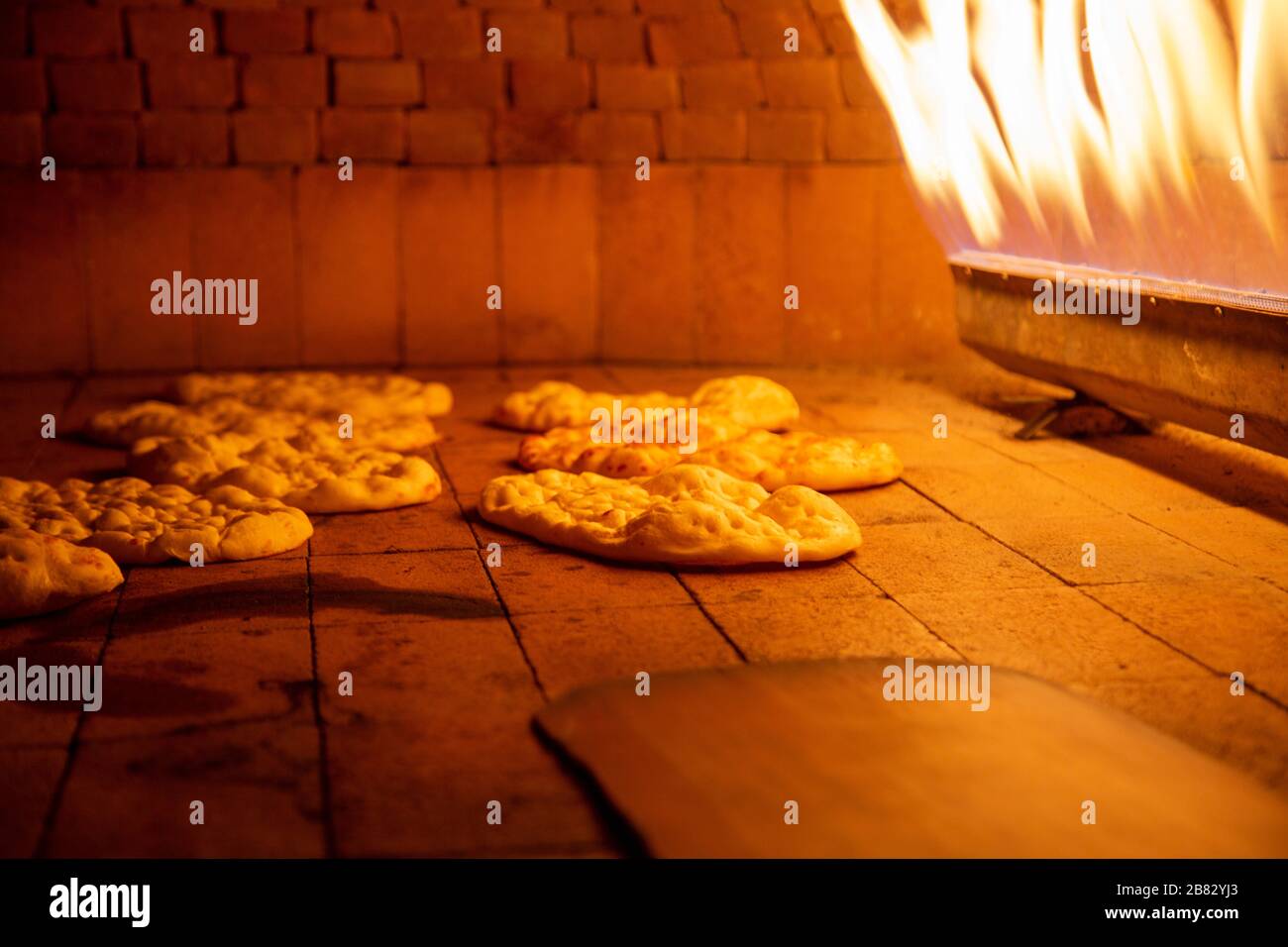 In a restaurant, pita or pide bread cooking in oven or stove. Bakery or ...