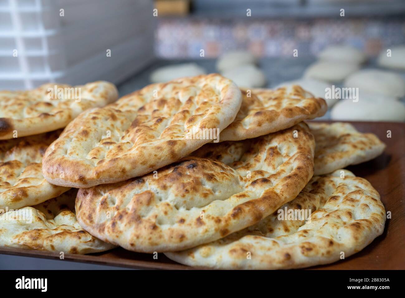 In a restaurant, pita or pide bread cooking in oven or stove. Bakery or ...