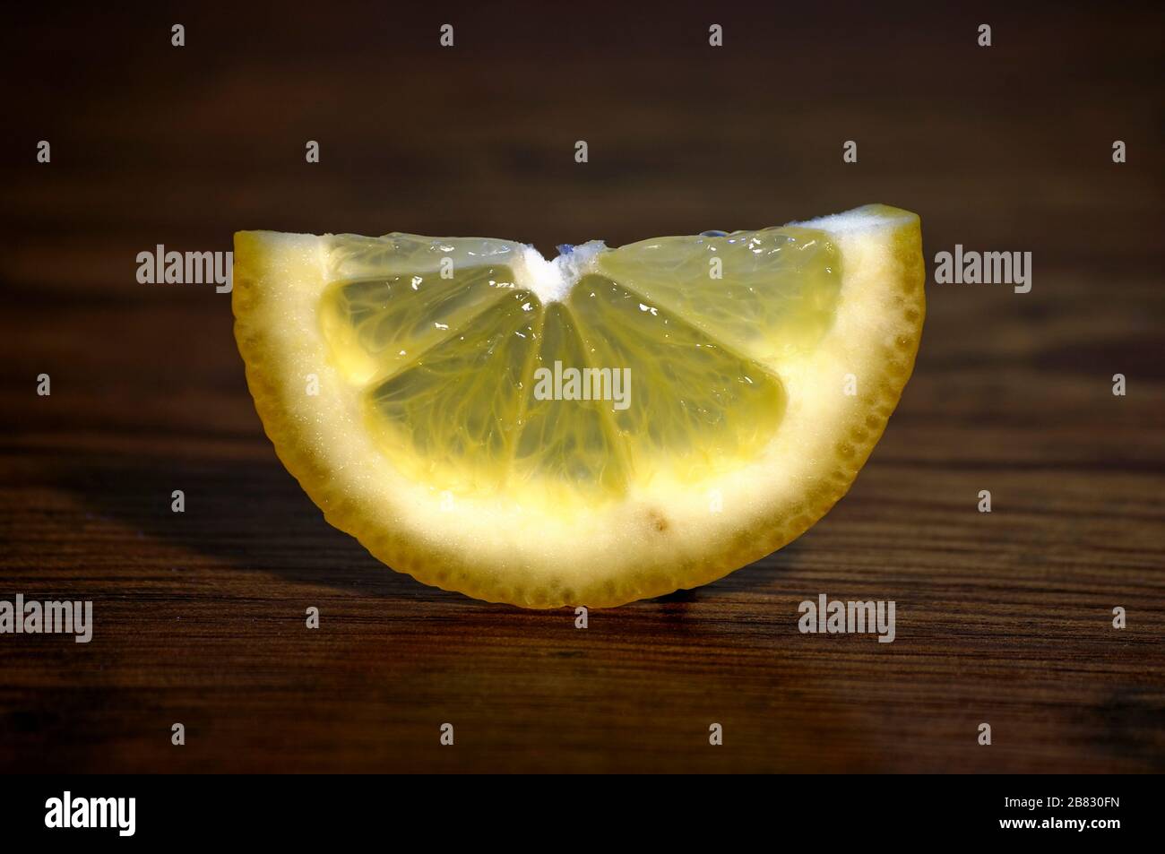 Still life of a lemon cut into a wedge. Ecological and seasonal Stock ...