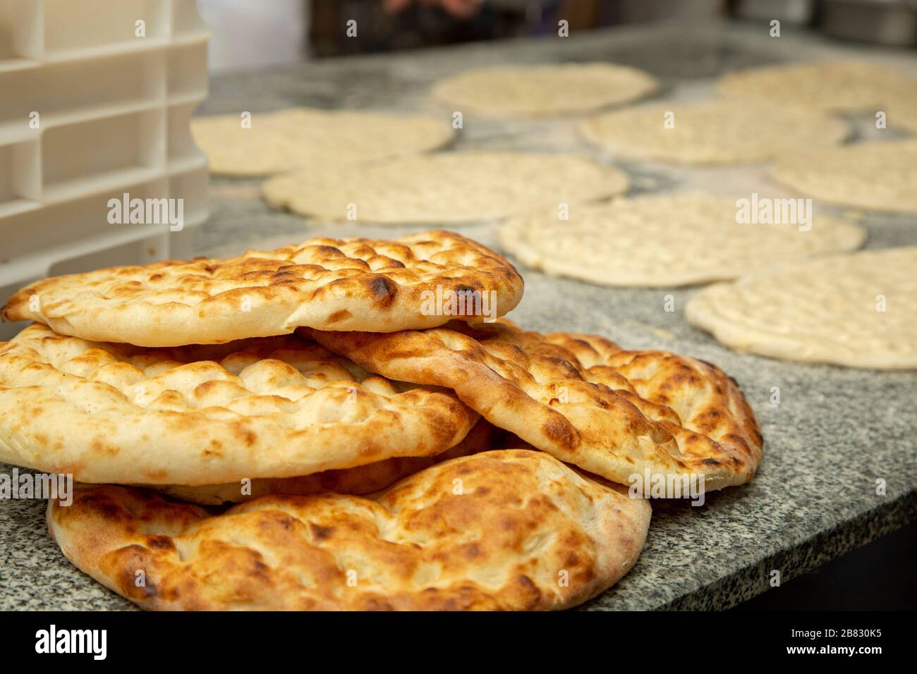In a restaurant, pita or pide bread cooking in oven or stove. Bakery or ...