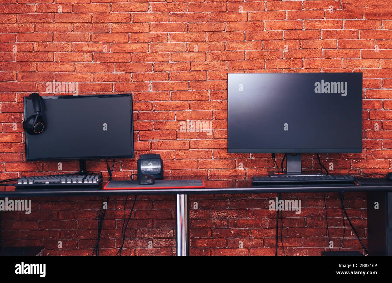 Two computer monitors with black screen on a desk, one workplace on ...