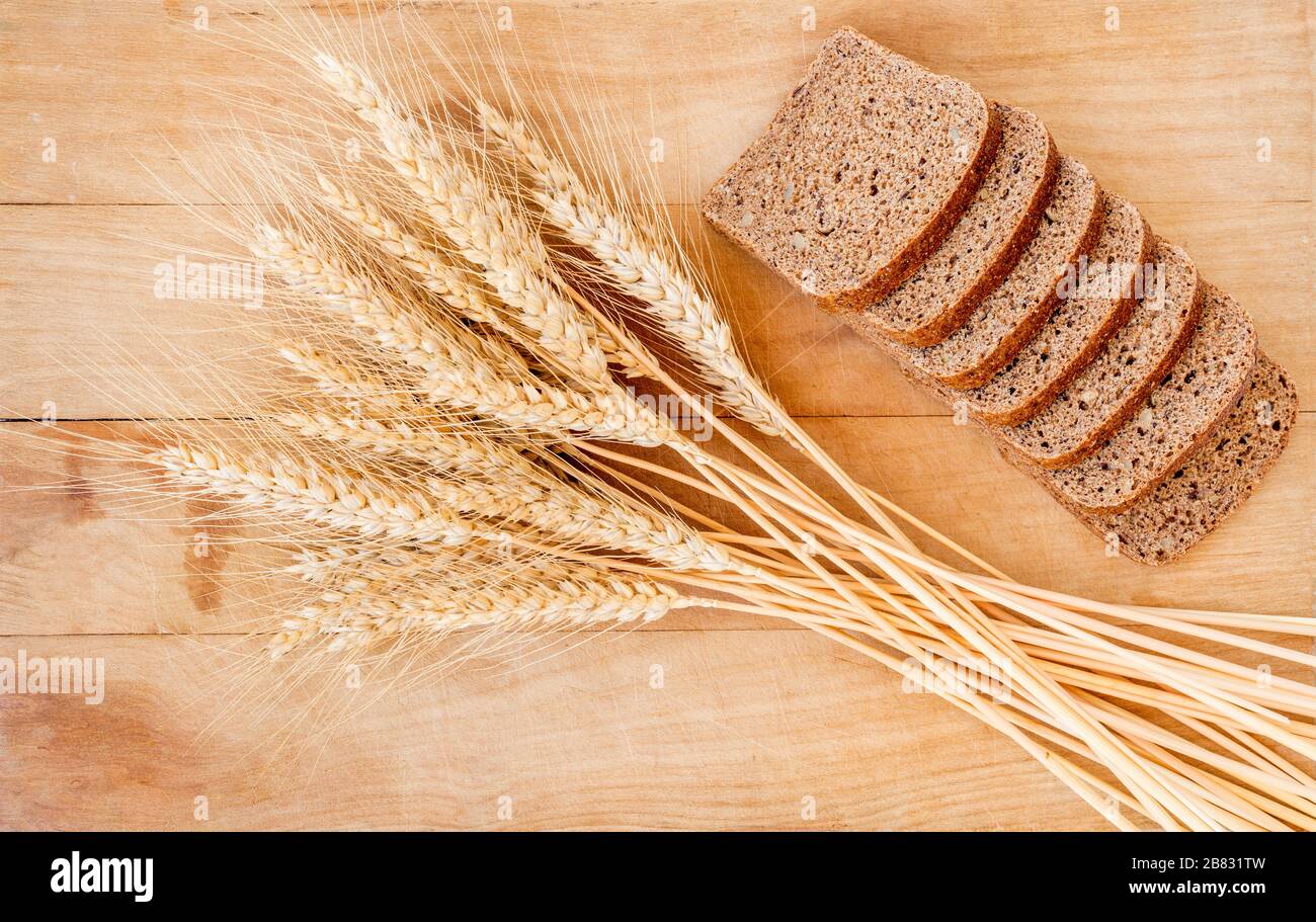 Rustic bread and wheat on an old vintage planked wood table. Old wood ...