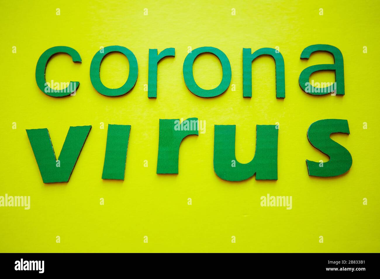 Word CORONAVIRUS made of green cardboard letters, isolated on yellow ...
