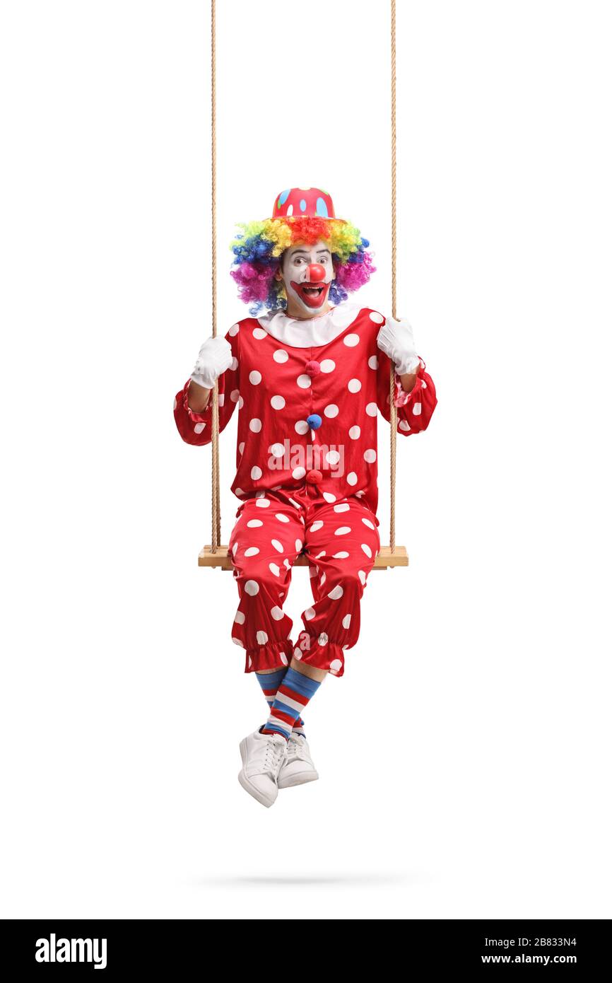 Cheeky clown swinging on a wooden swing isolated on white background ...