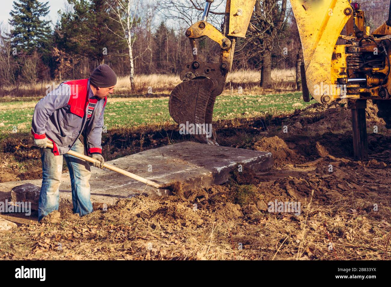 The bucket excavator pulls up concrete slabs to set the road Stock ...
